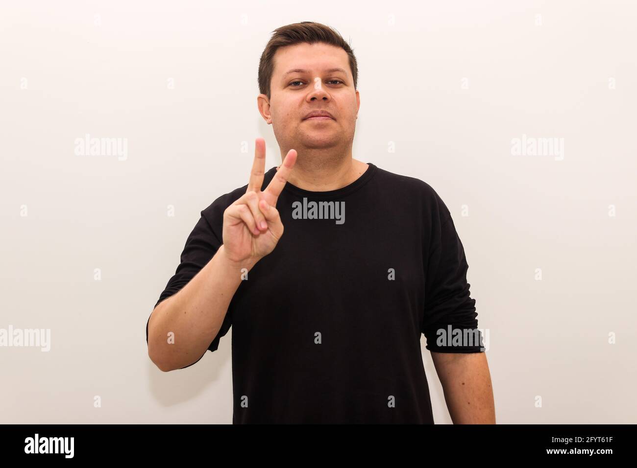 Young man showing peace sign hi-res stock photography and images - Alamy