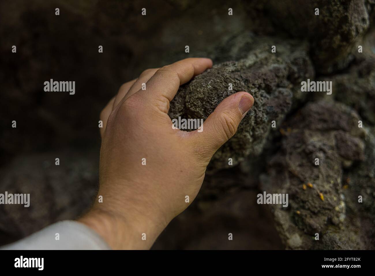 A female hand touching a rock on the wall; connection to nature Stock ...