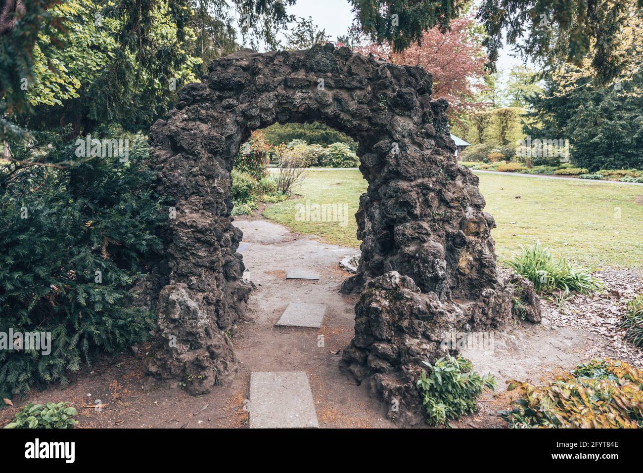 An old stone arch in the green landscaped garden Stock Photo - Alamy