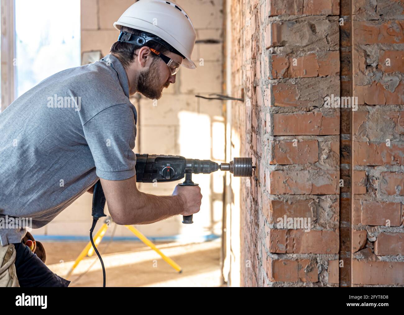 Close-up of the process of drilling a brick wall at a construction site ...
