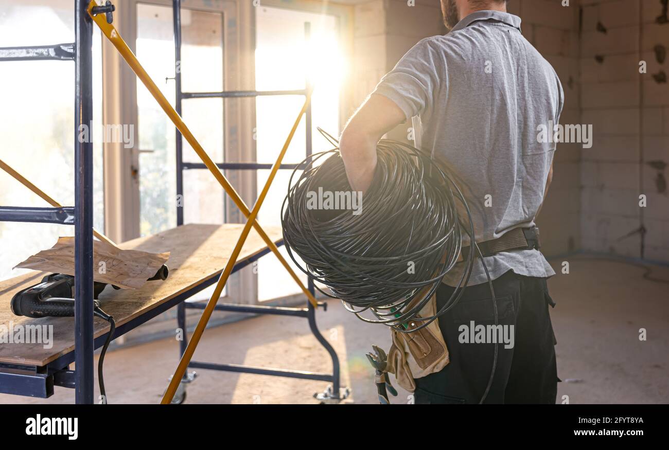 An electrician examines a construction drawing while holding an ...