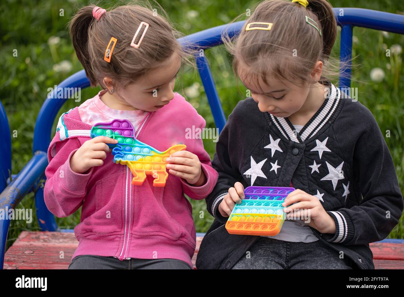 Little girls playing a new fidget toy popular with children helps them ...