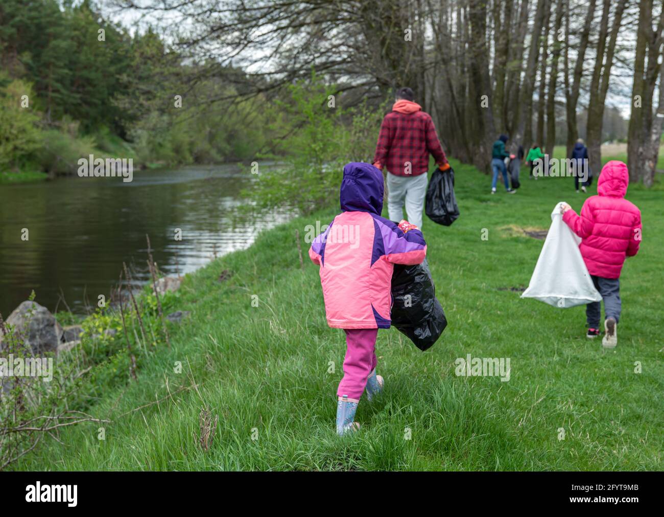 A group of people clean up the trash at the exit to the forest, in the ...