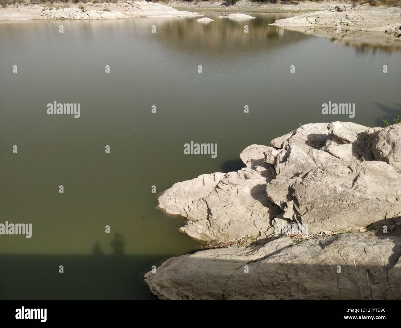 A high angle shot of the lake and rocky shore in Rajasthan in India ...