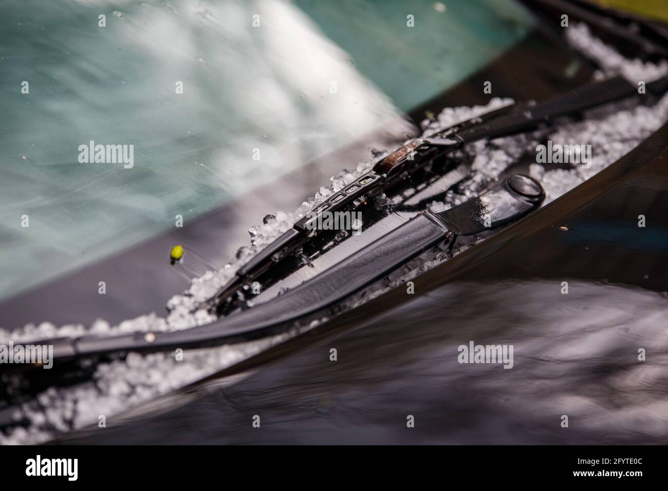 small hail ice balls on black car hood after heavy summer storm close ...