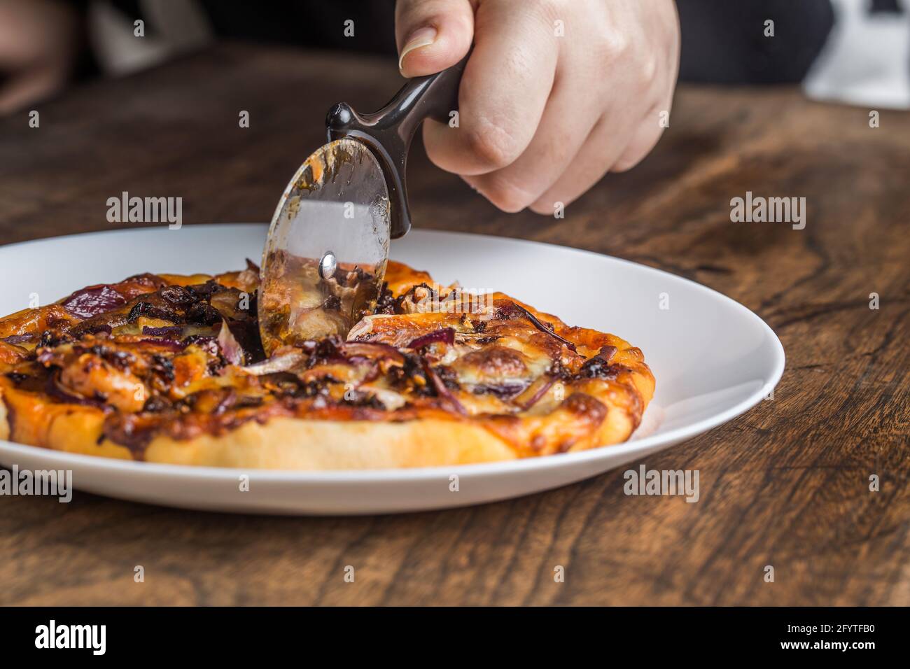 Chef cuts freshly prepared pizza slices Stock Photo - Alamy