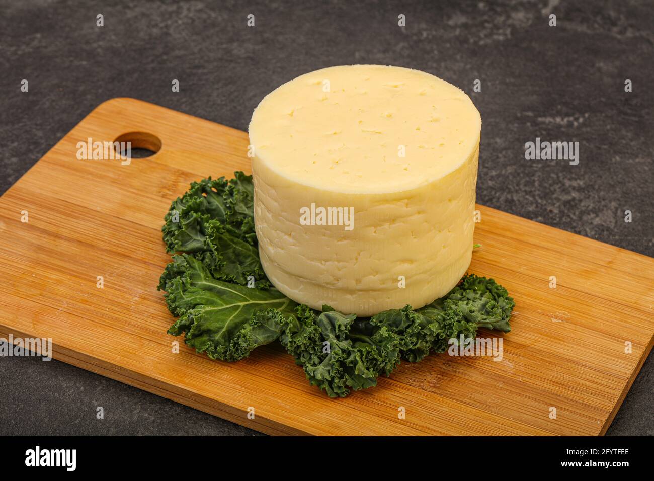 Yellow round dairy soft cheese piece Stock Photo - Alamy