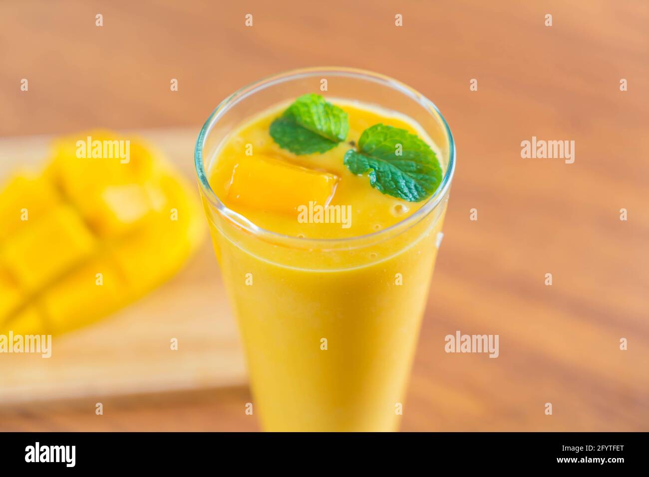 fresh mango smoothie on wood background Stock Photo - Alamy