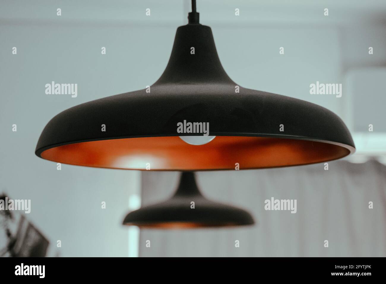 A selective focus shot of a vintage style lamp hanging from the ceiling ...