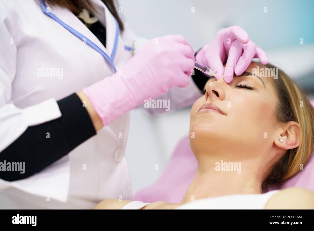 Doctor performing rhinoplasty by injection of hyaluronic acid in the ...