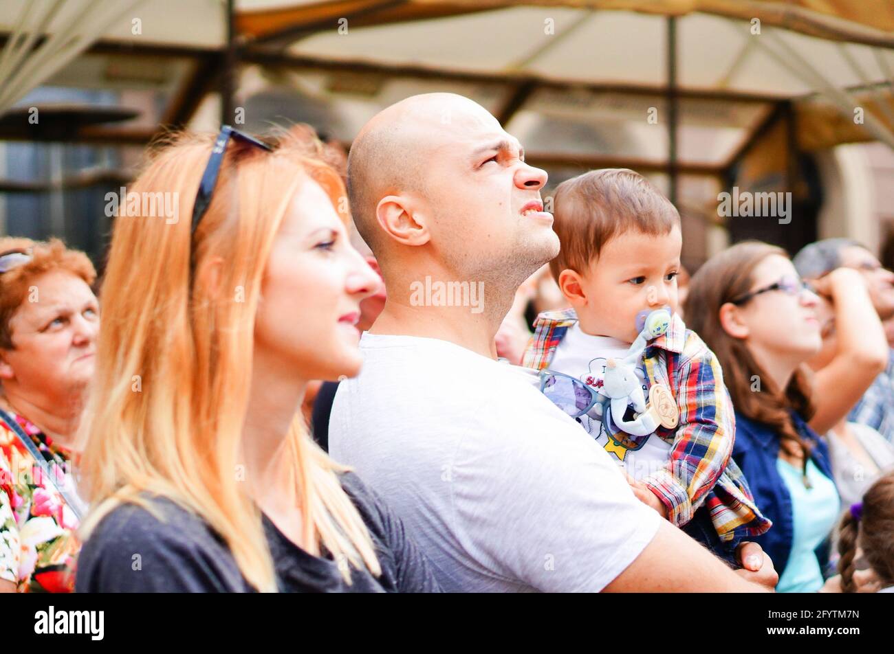 POZNAN, POLAND - Feb 05, 2016: Bald man holding baby boy and looking up ...