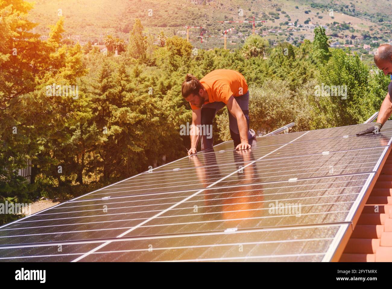 Workers assemble energy system with solar panel for electricity Stock ...