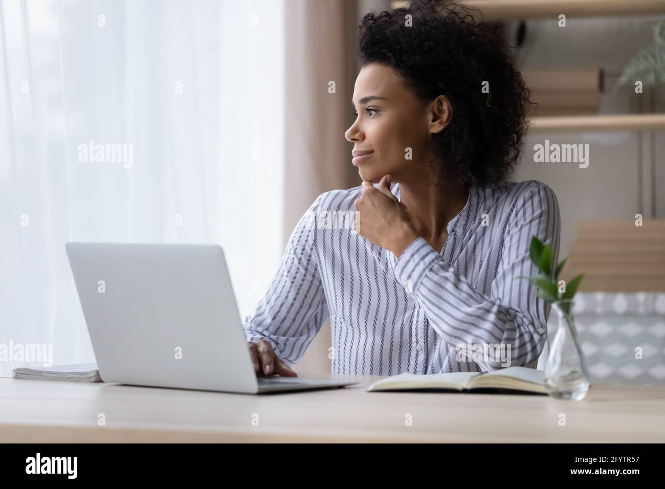 Pensive biracial woman work on computer making plans Stock Photo - Alamy