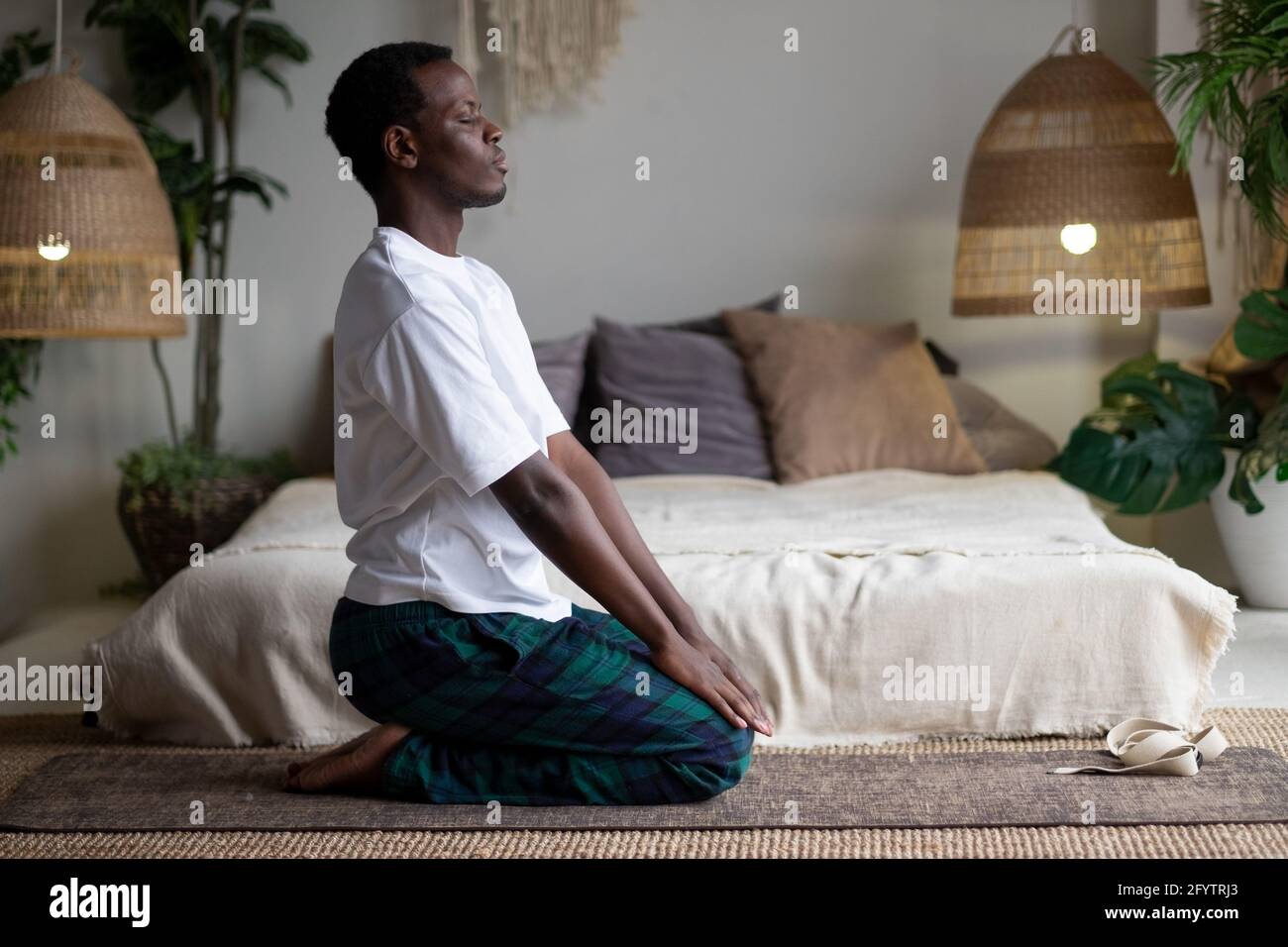 African man practicing yoga and meditation at home Stock Photo - Alamy