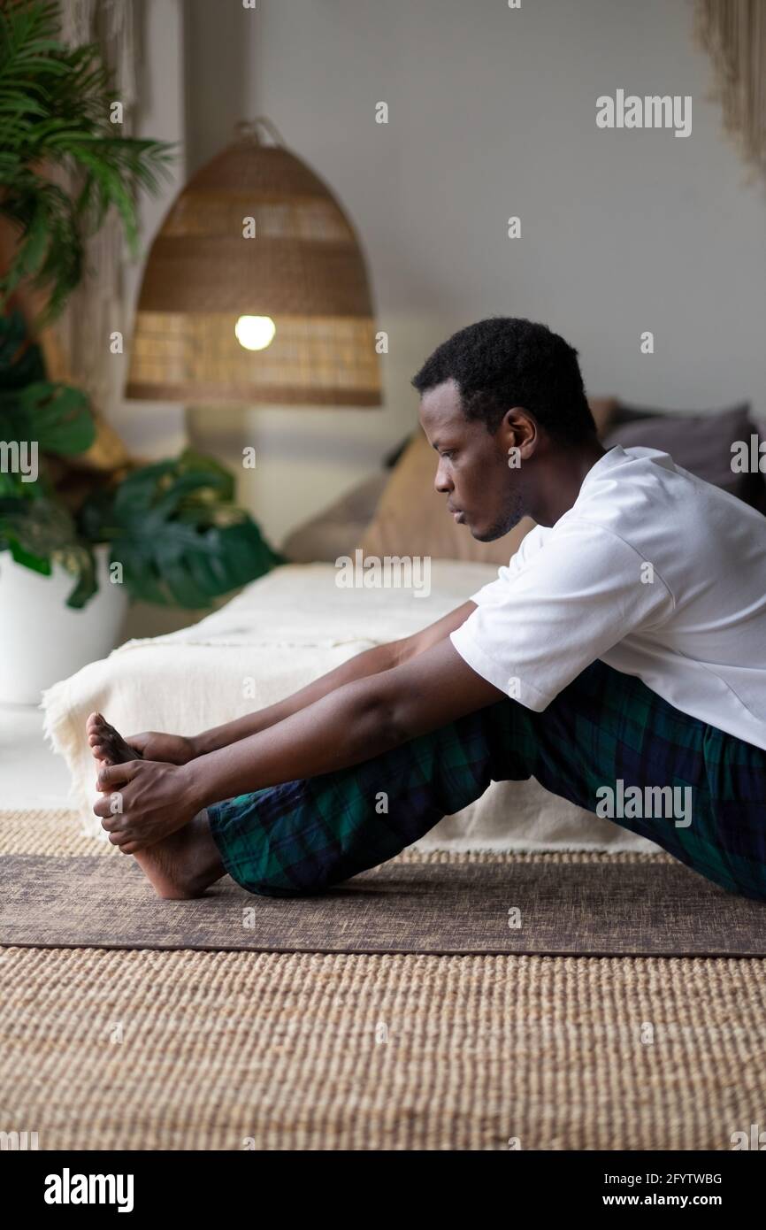 African young man sitting in paschimottanasana or Intense Dorsal ...