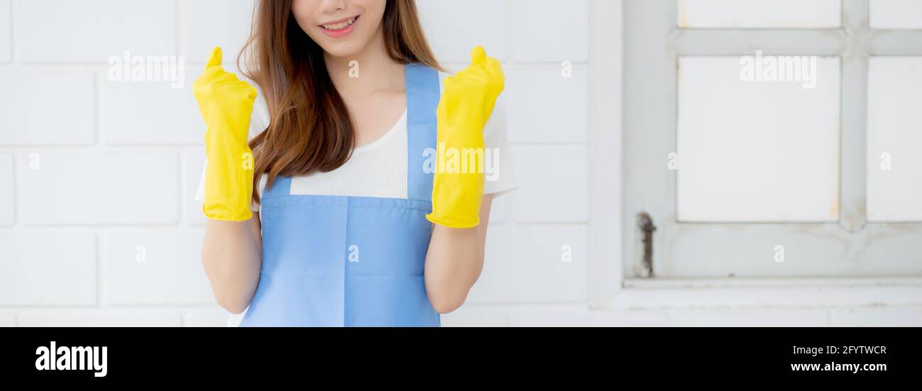 Portrait young asian woman is housekeeper in rubber gloves and apron ...