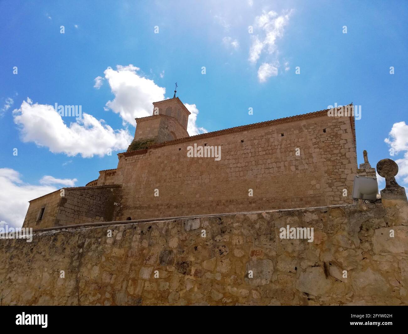 A low angle shot of Romanesque stone church with blue sky in the ...