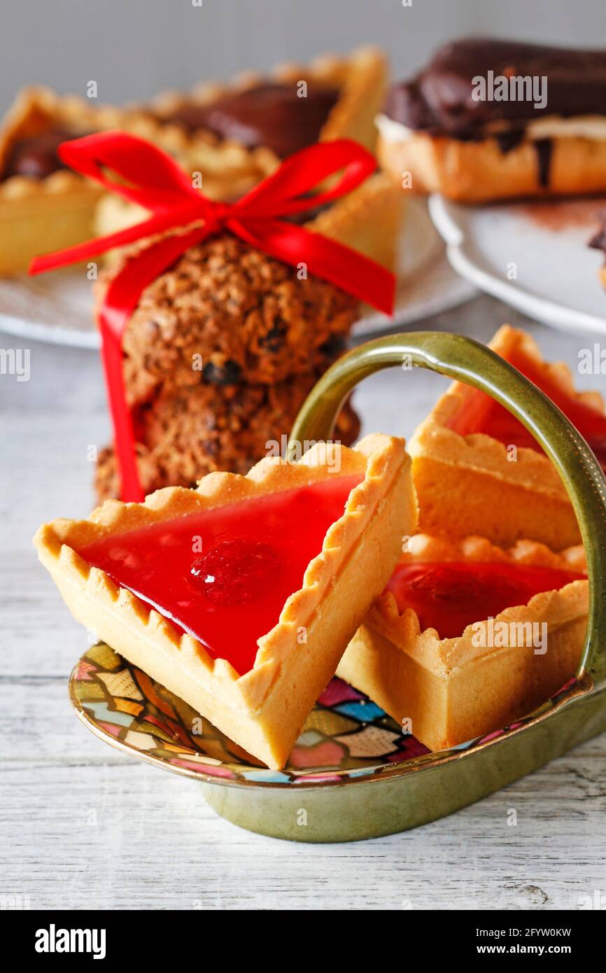 Triangle cookies with red fruit jelly. Party dessert Stock Photo - Alamy