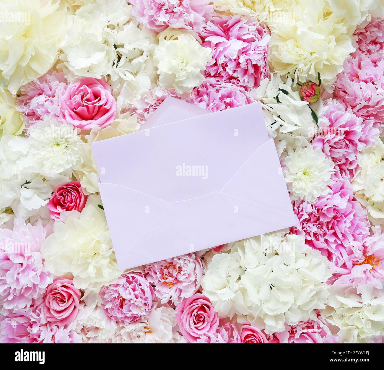 Traditional envelope lying on flower background with peonies, roses and ...