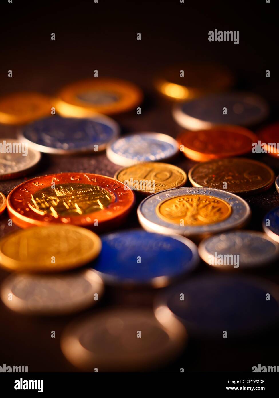 A vertical shot of shining coins' collection in the black background ...
