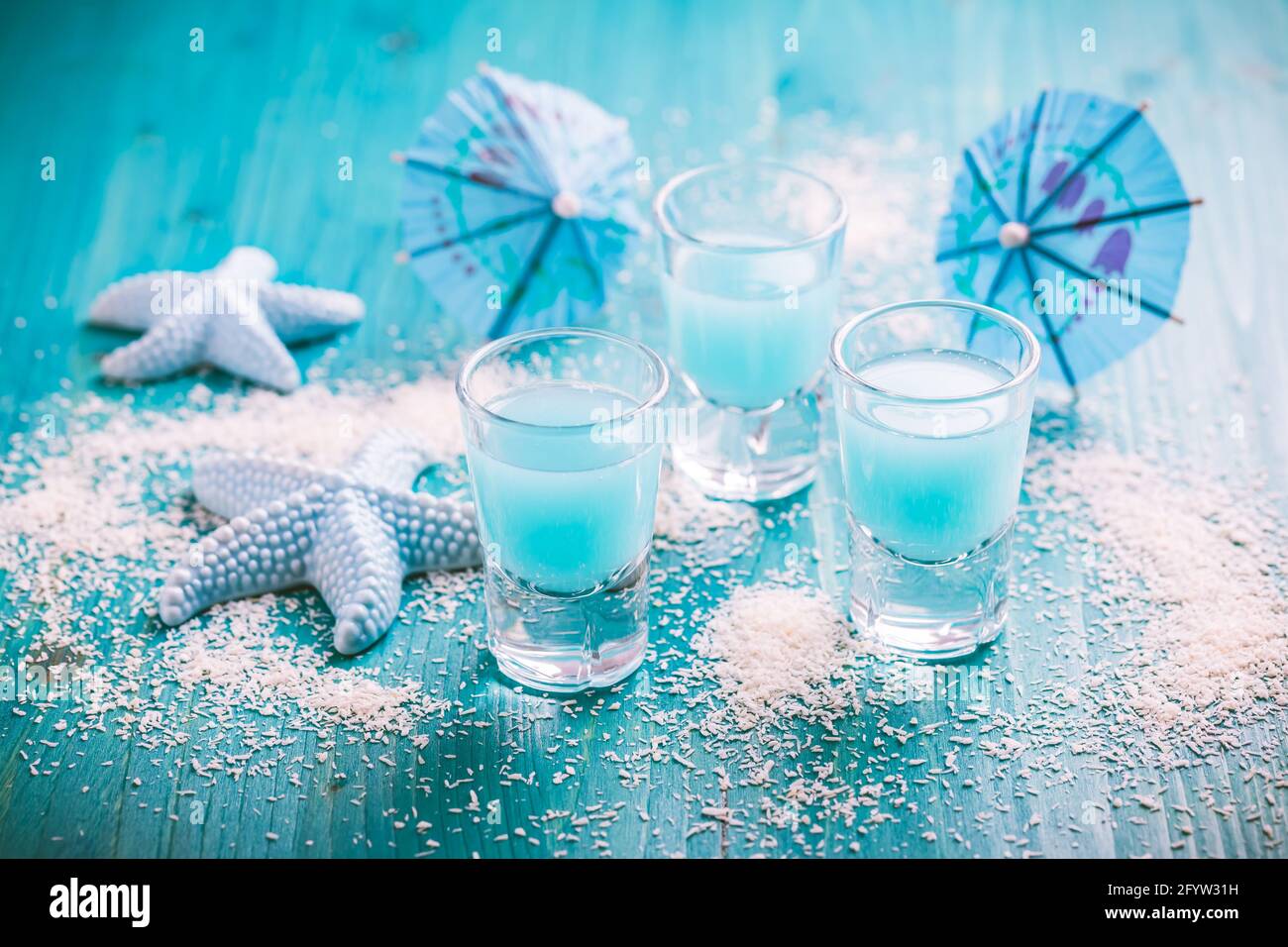 Blue shots for summer with seashells on blue background. Small ...