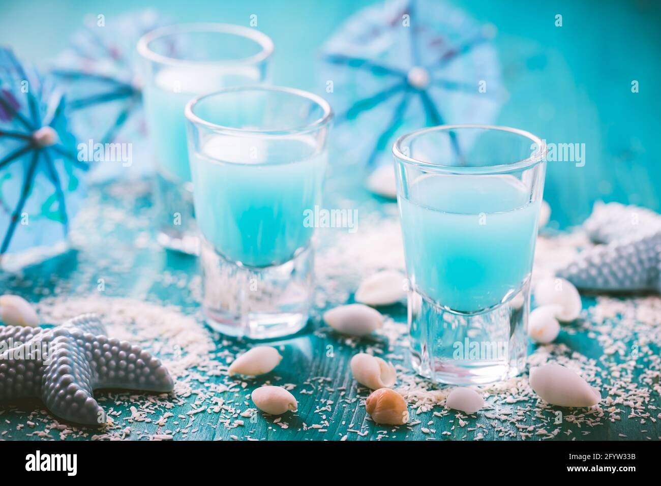 Blue shots for summer with seashells on blue background. Small ...