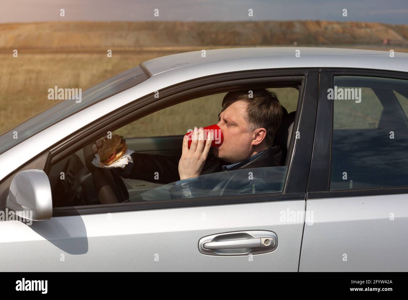 The manager eats lunch at the wheel in the car Stock Photo - Alamy