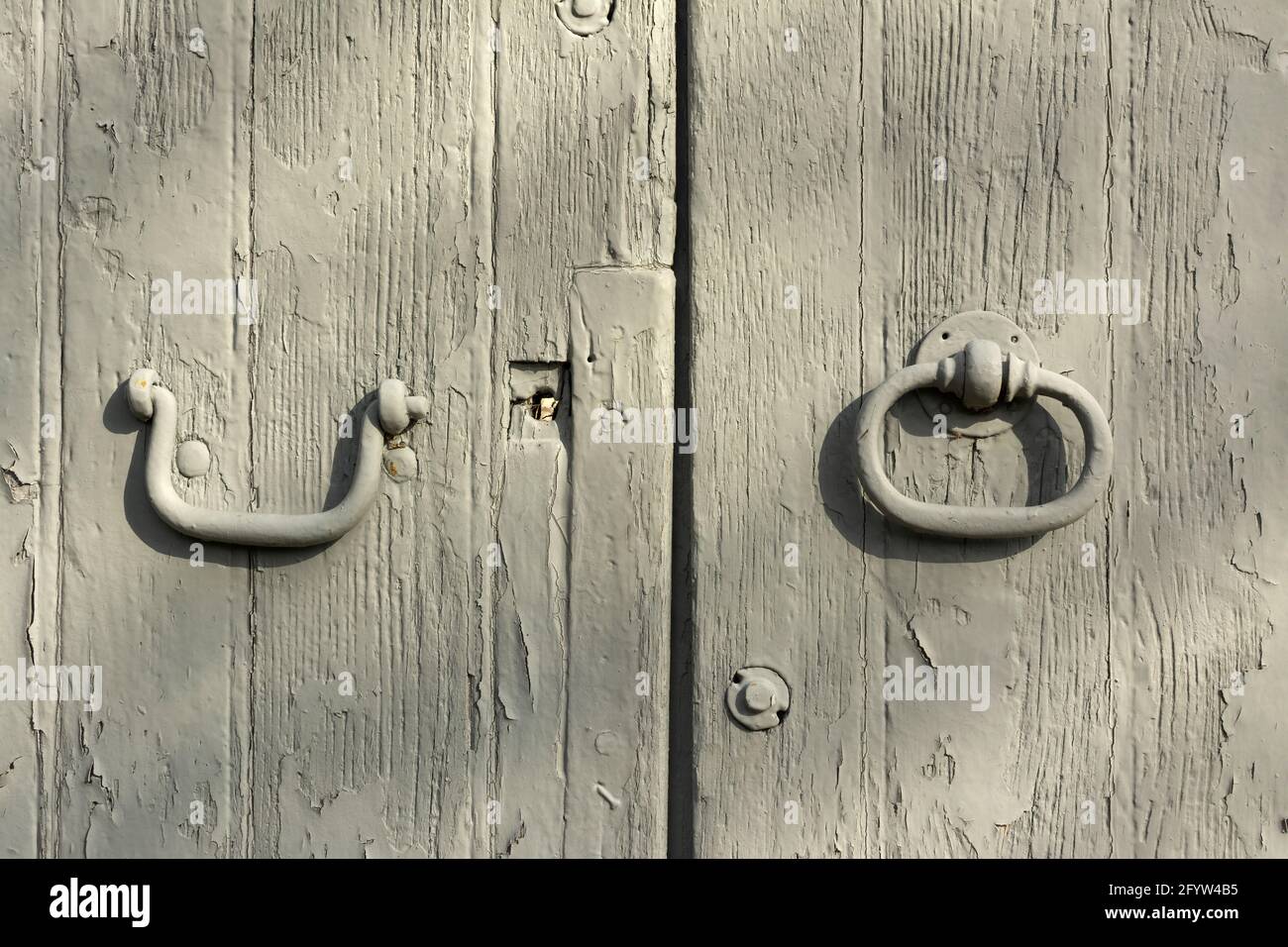 A closeup shot of old wooden surfaced painted in gray with two metal ...