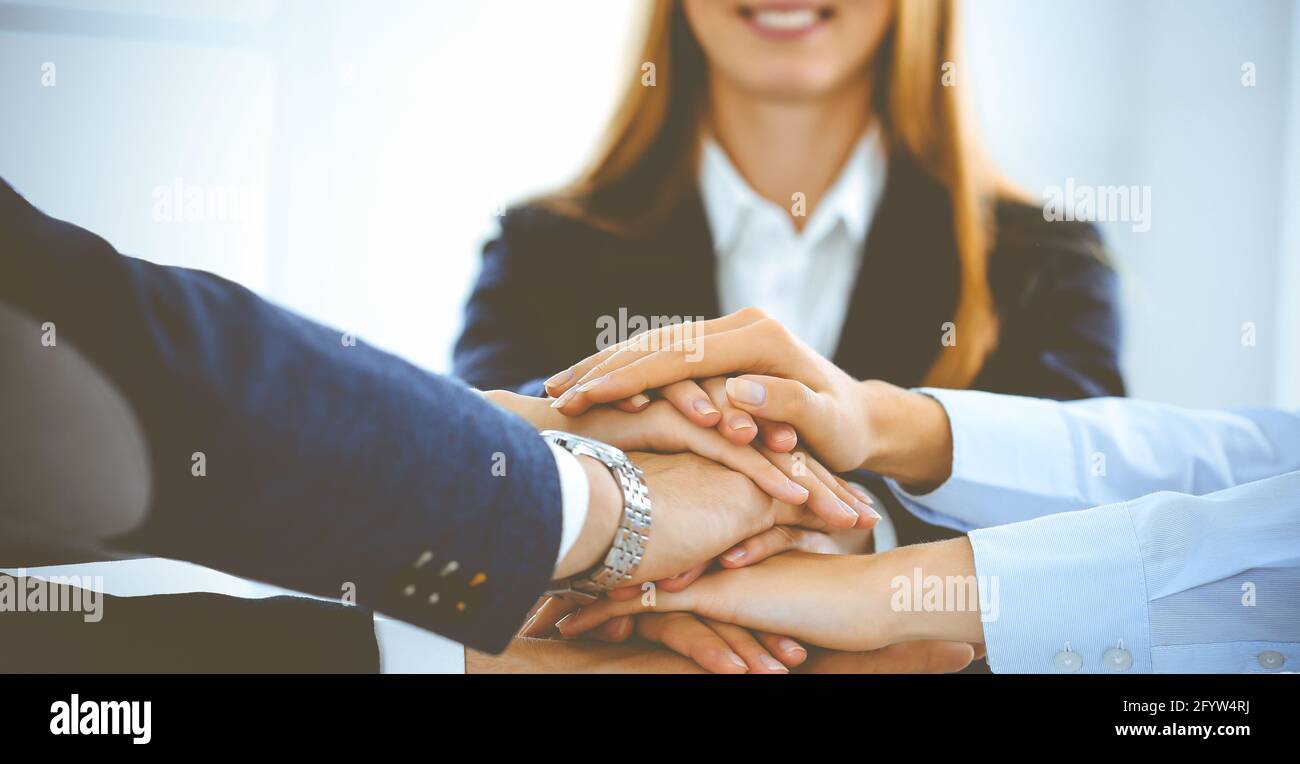 Business team showing unity with their hands together. Group of people joining hands and ...