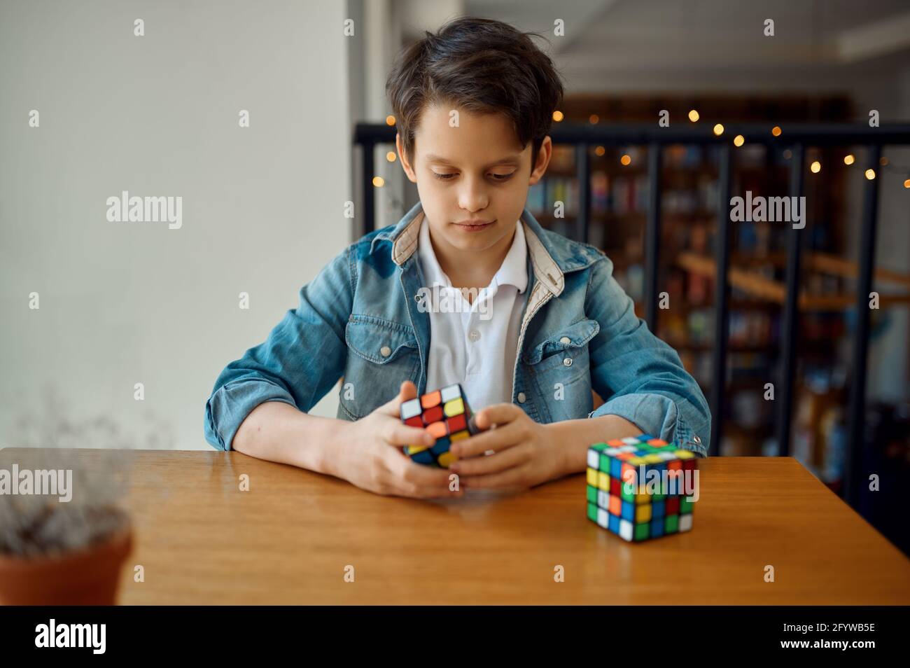 Boy trying to solve puzzle cube Stock Photo - Alamy