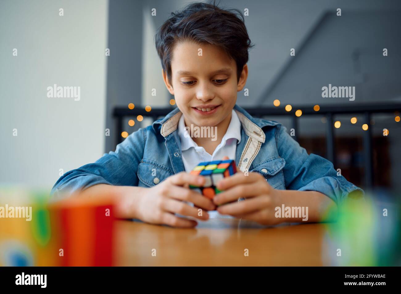 Little boy trying to solve puzzle cubes Stock Photo - Alamy