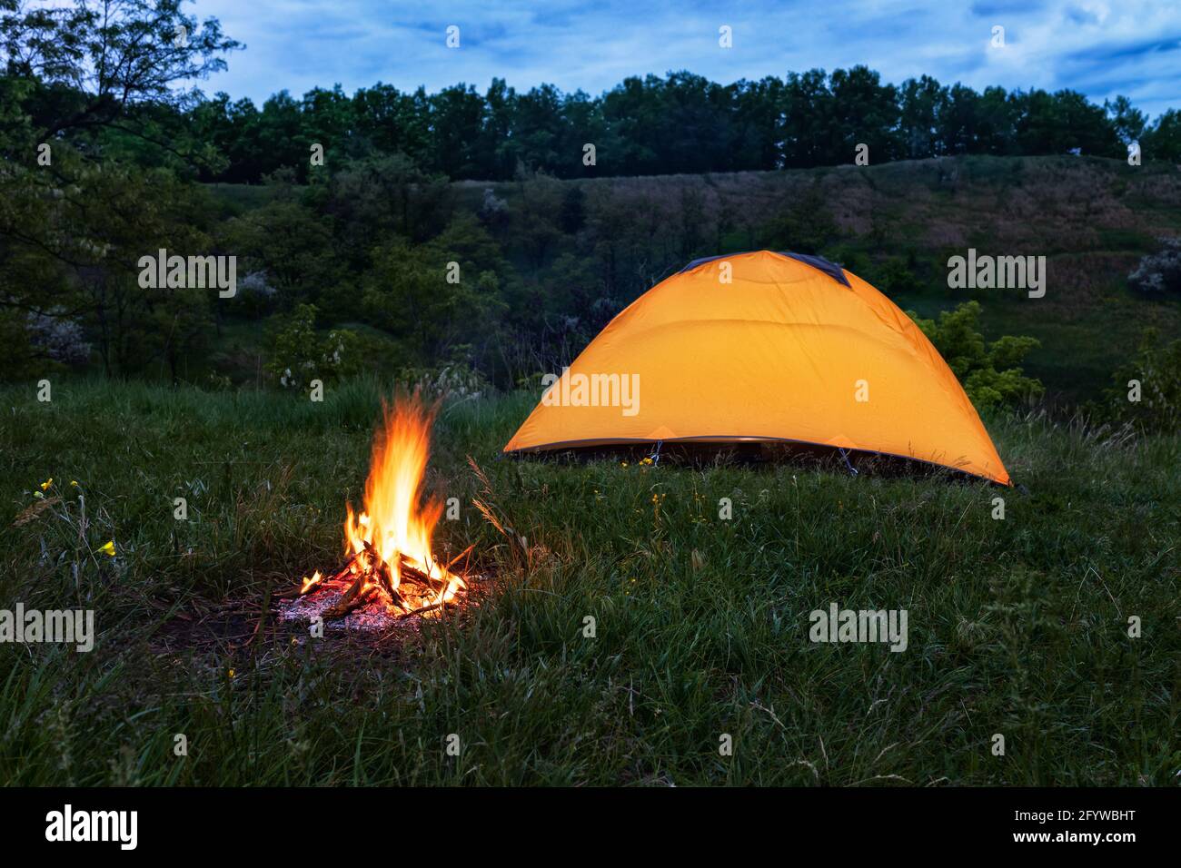 bonfire and yellow tourist tent on meadow Stock Photo - Alamy