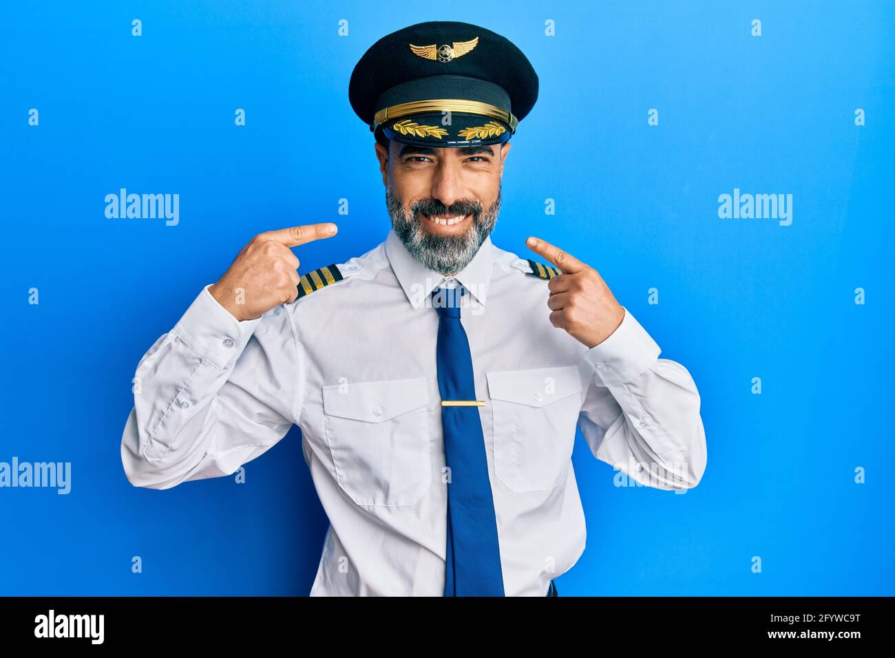 Middle age man with beard and grey hair wearing airplane pilot uniform ...