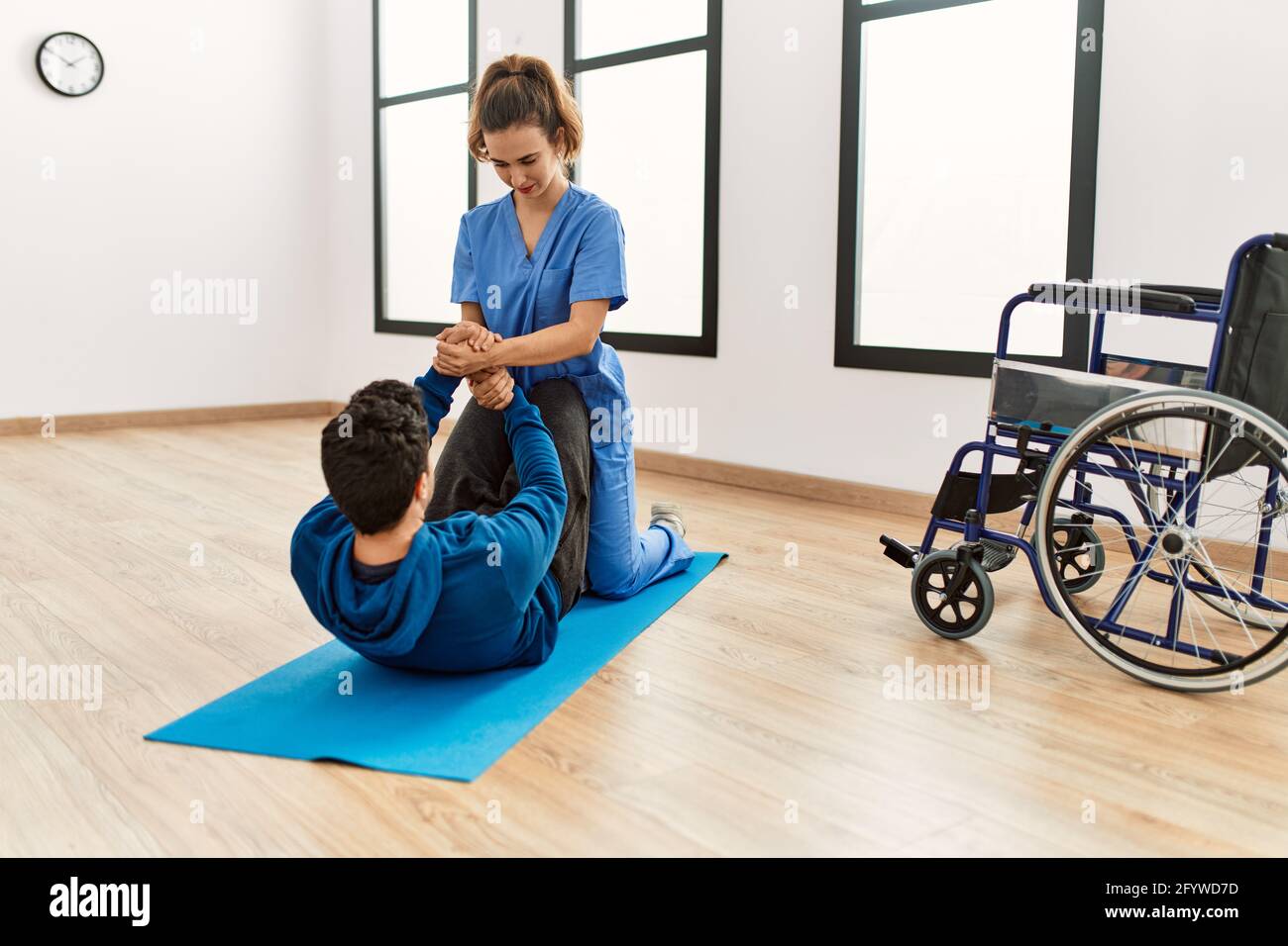 Young disabled man making mobility exercise at the clinic Stock Photo ...
