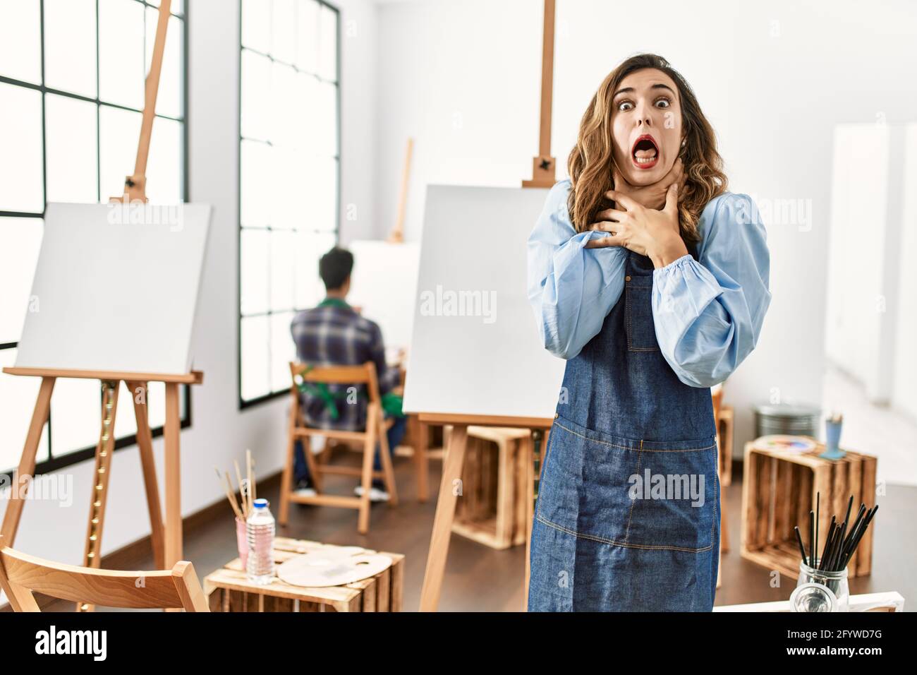 Young artist woman at art studio shouting and suffocate because painful ...
