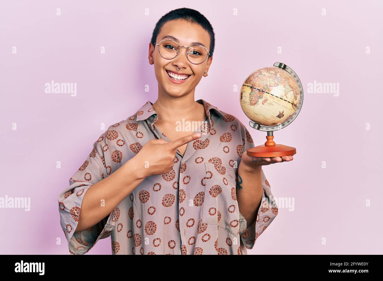 Beautiful hispanic woman with short hair holding small world ball ...
