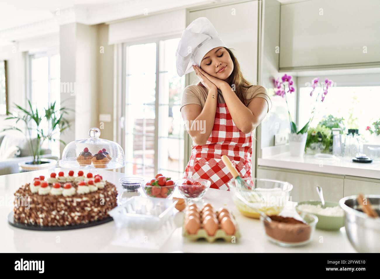 Beautiful young brunette pastry chef woman cooking pastries at the ...