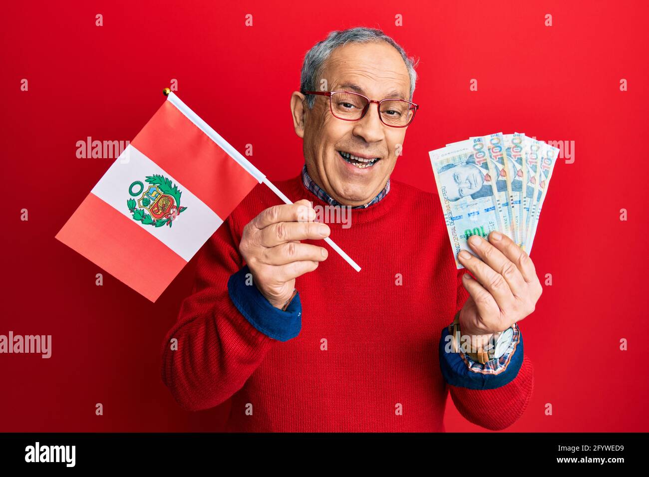 Handsome senior man with grey hair holding peru flag and peruvian sol ...