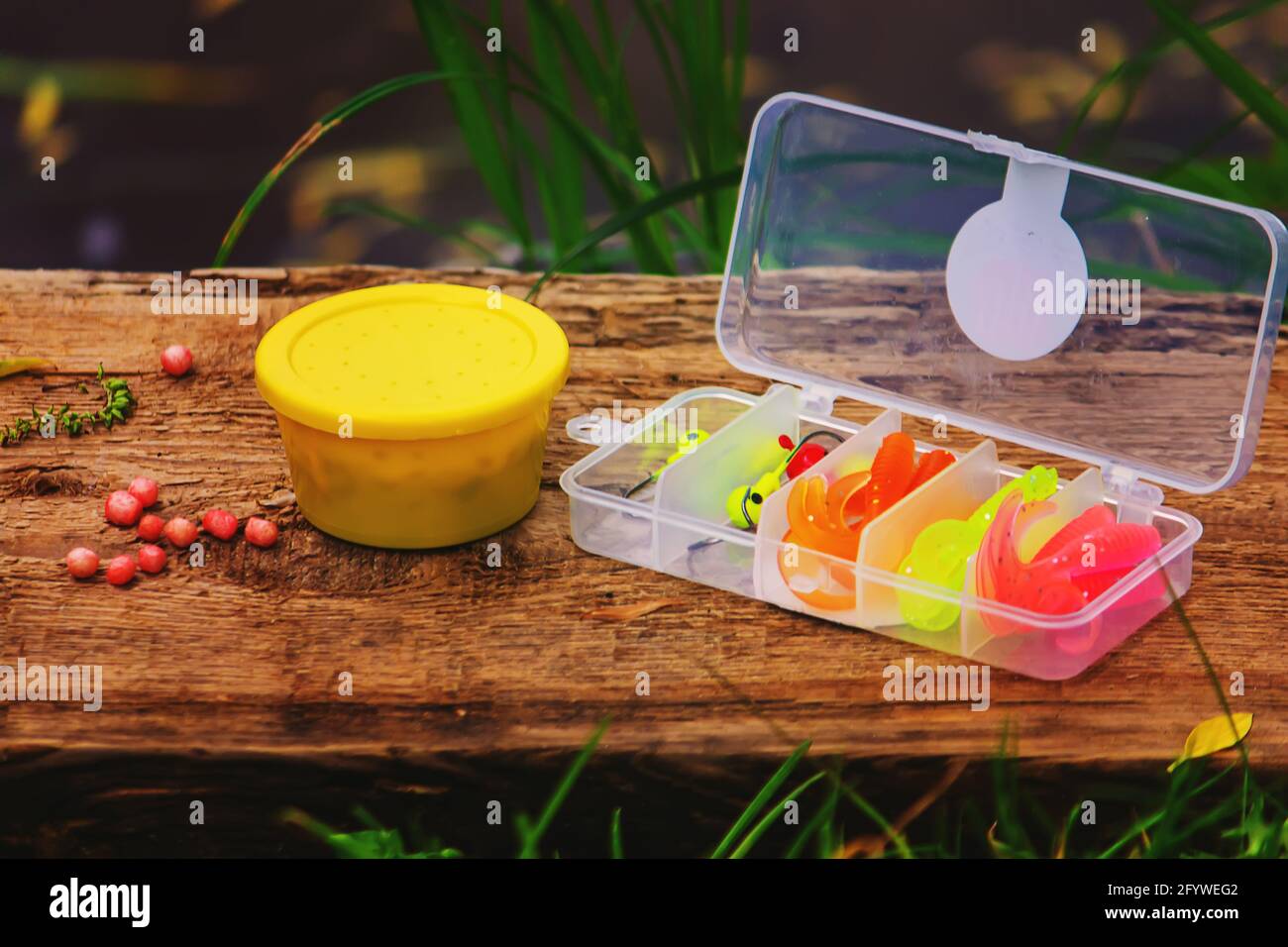 many colorful lures for fishing on the wooden pier. Selective focus ...