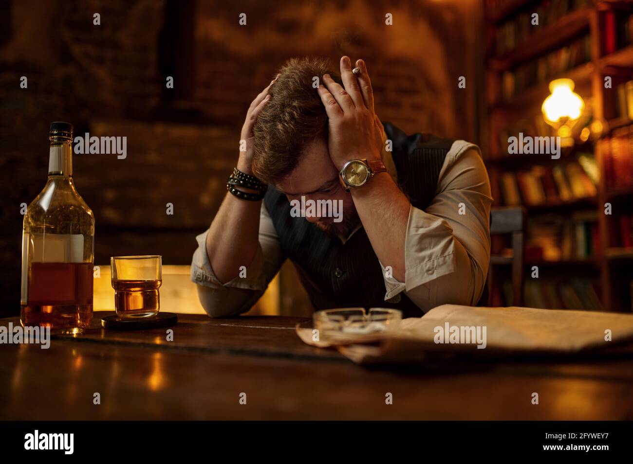 Tired man smokes cigarette and drinks alcohol Stock Photo - Alamy