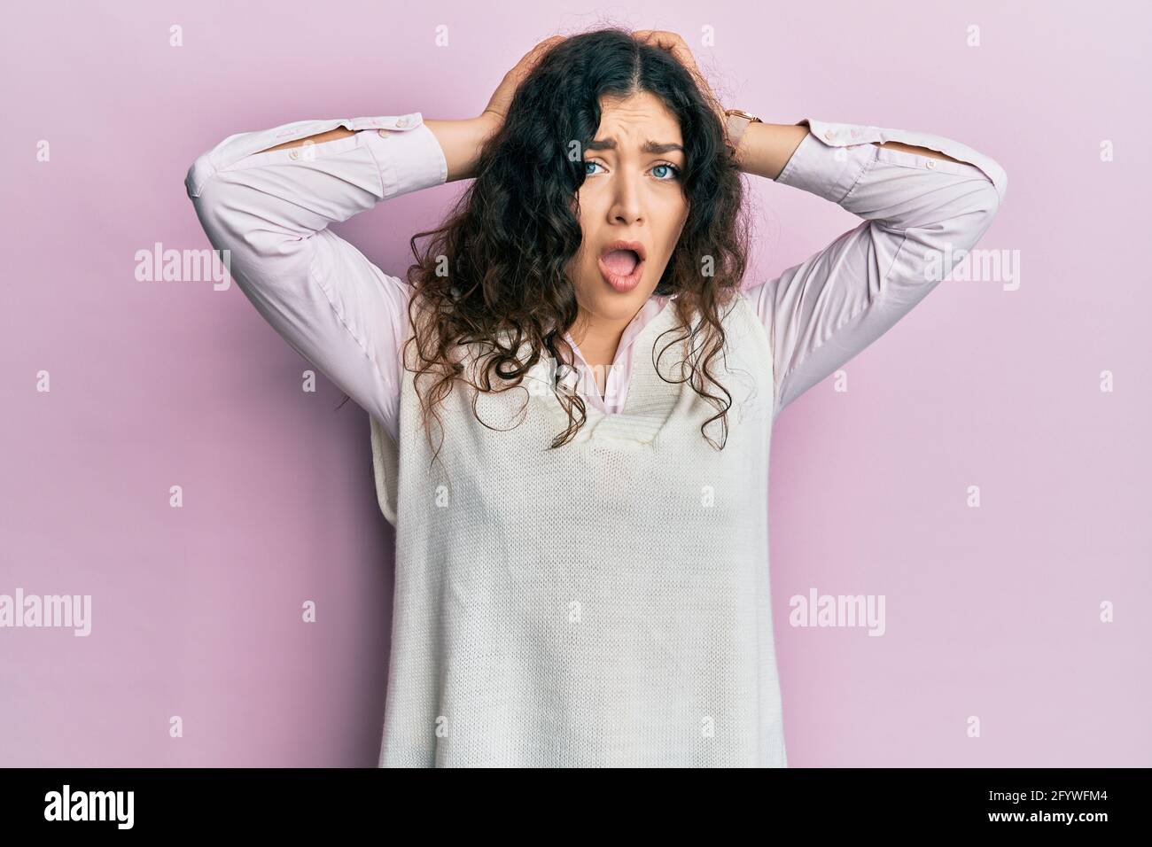 Young brunette woman with curly hair wearing casual clothes crazy and ...