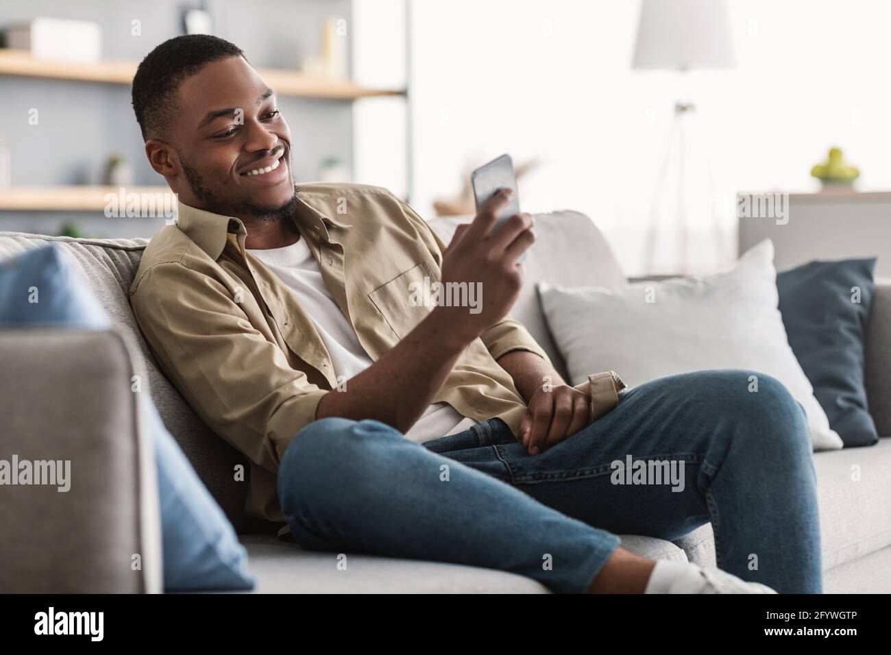 Side View Of African American Guy Using Smartphone At Home Stock Photo ...
