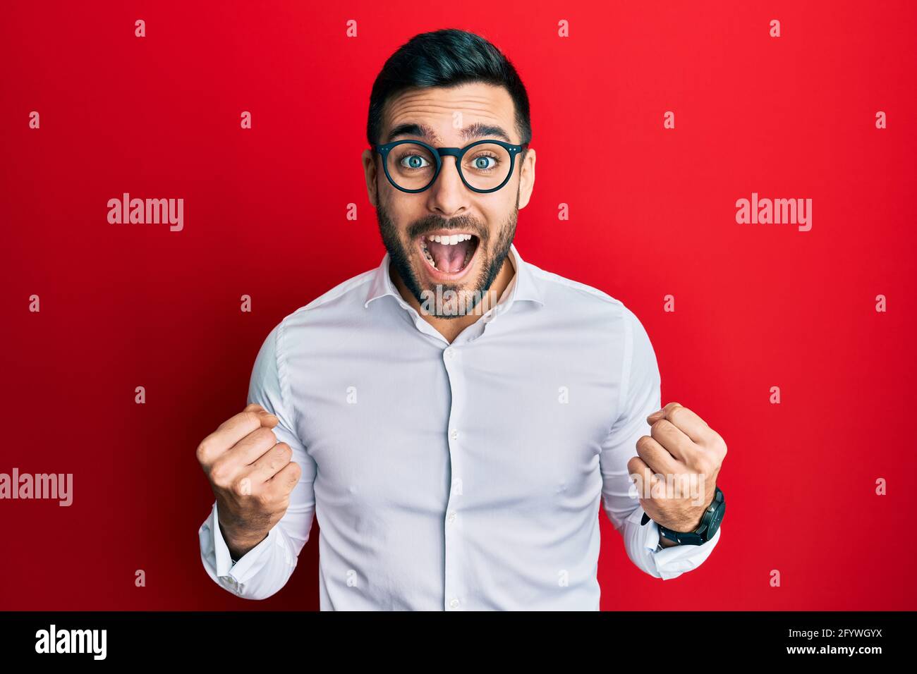 Young hispanic businessman wearing shirt and glasses celebrating ...