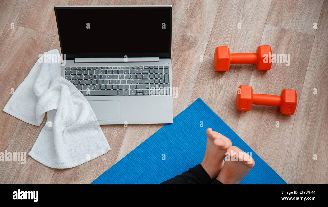 Towel dumbbells laptop Top view. Young woman do fitness workout ...