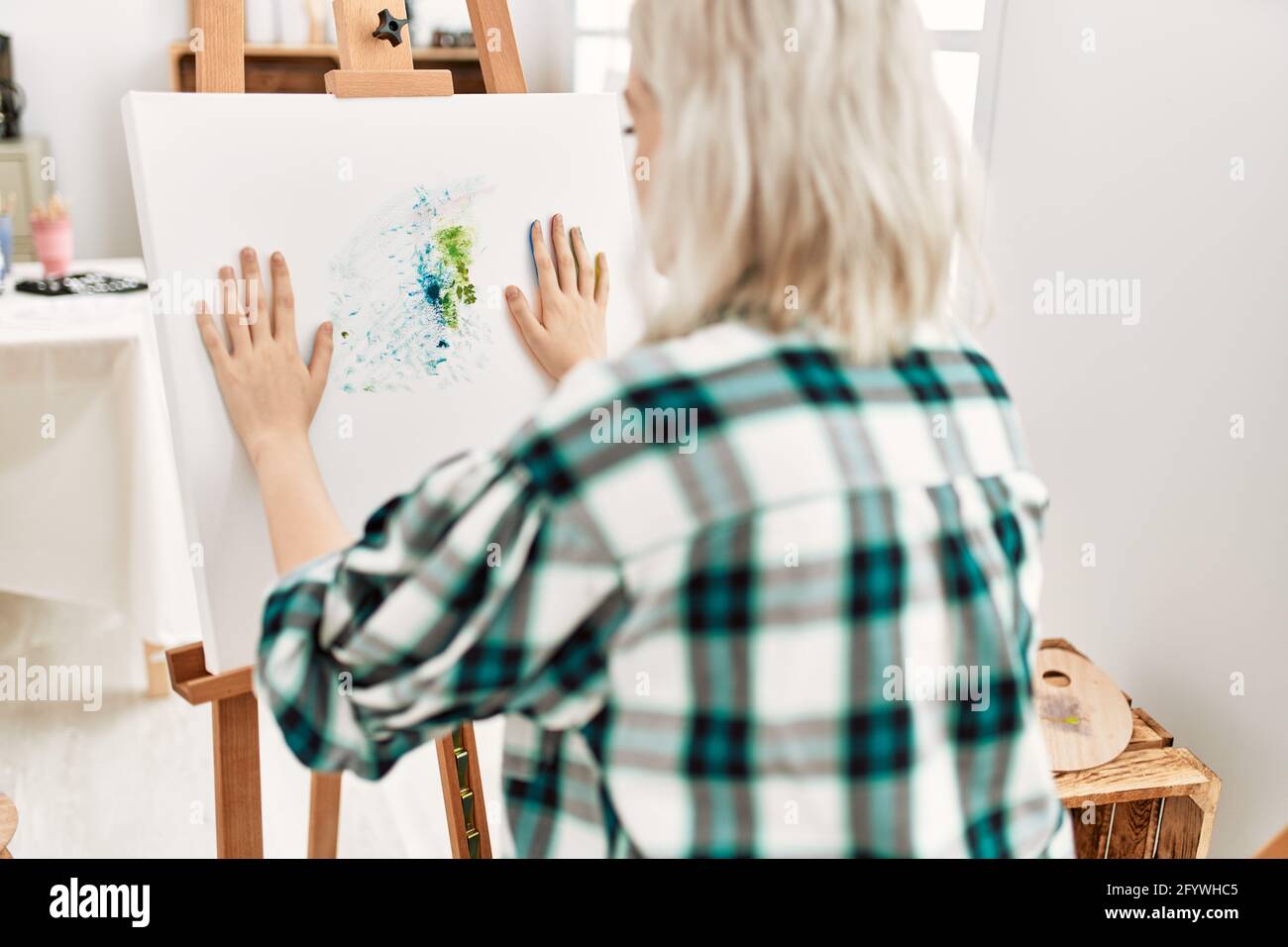 Young artist student girl on back view painting canvas with painted ...