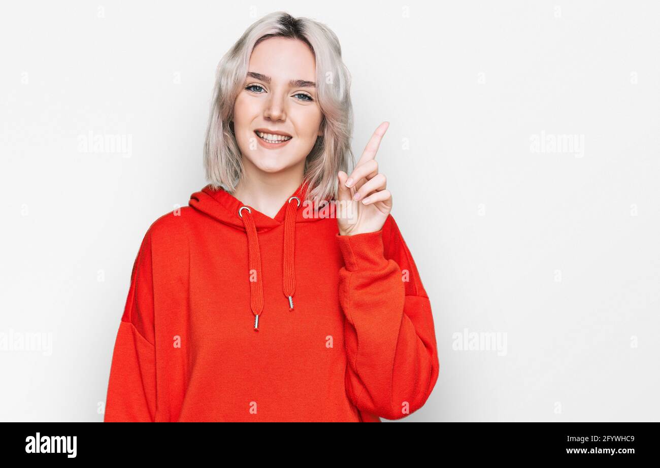 Young blonde girl wearing casual clothes showing and pointing up with ...
