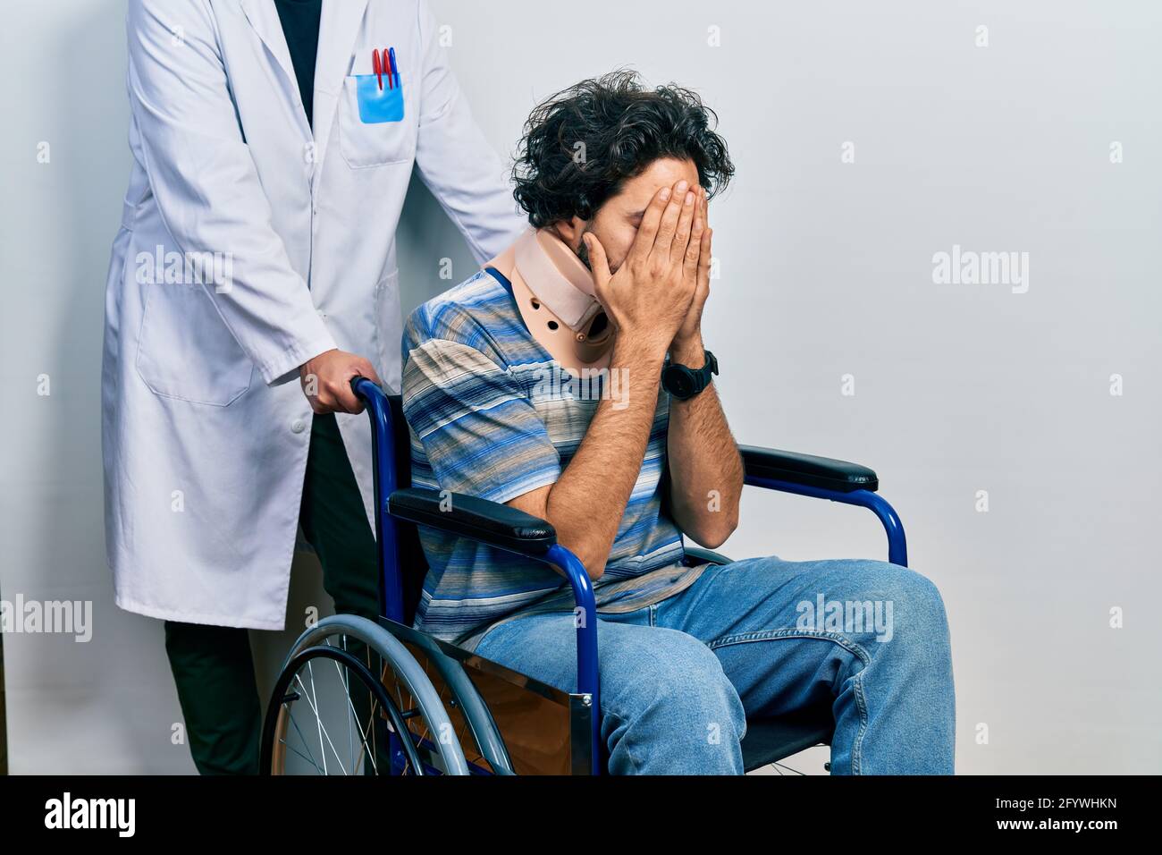 Handsome hispanic man sitting on wheelchair wearing neck collar with ...
