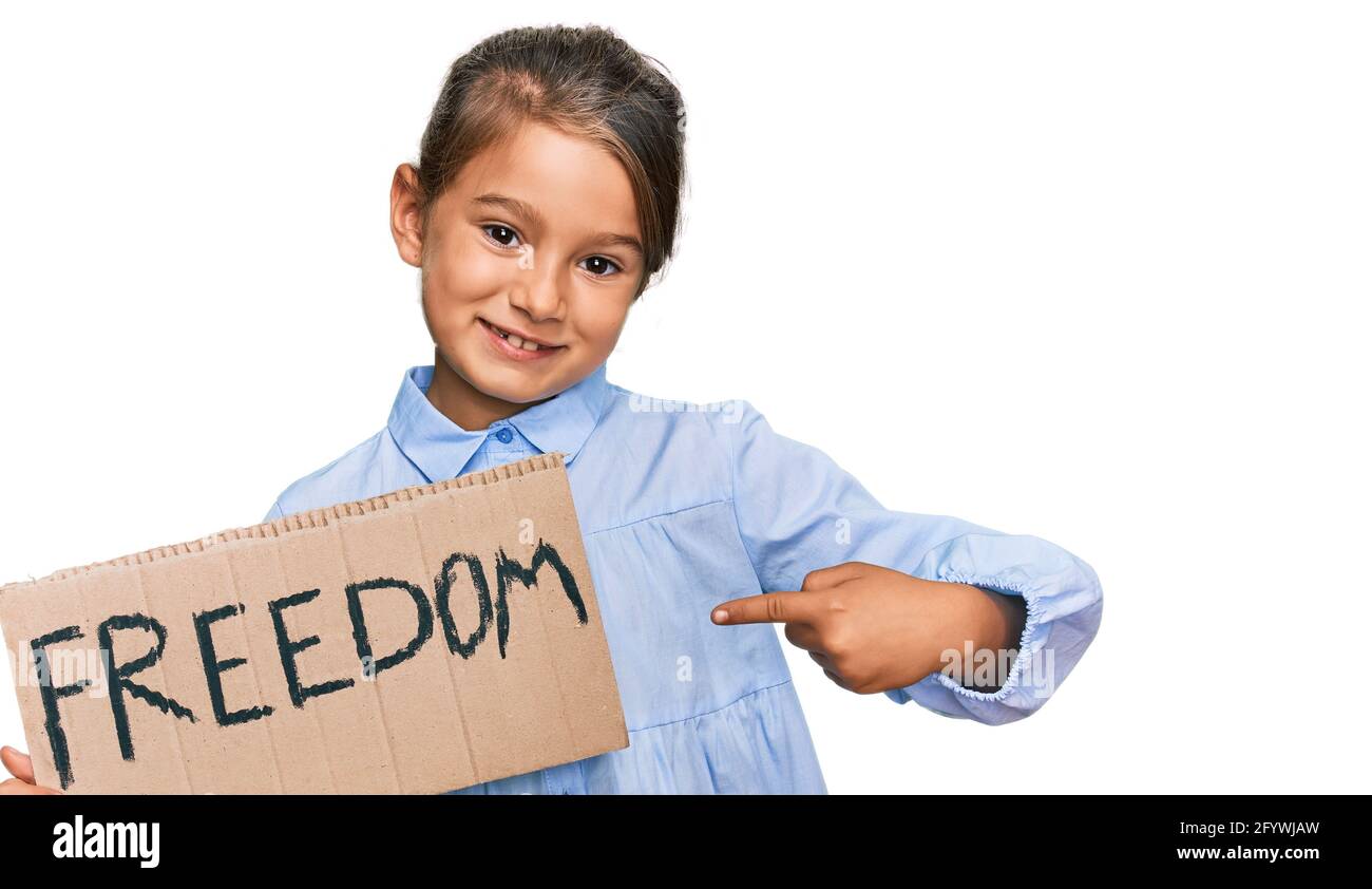 Little beautiful girl holding freedom banner smiling happy pointing ...