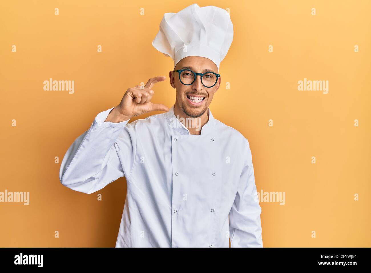 Bald man with beard wearing professional cook uniform smiling and ...