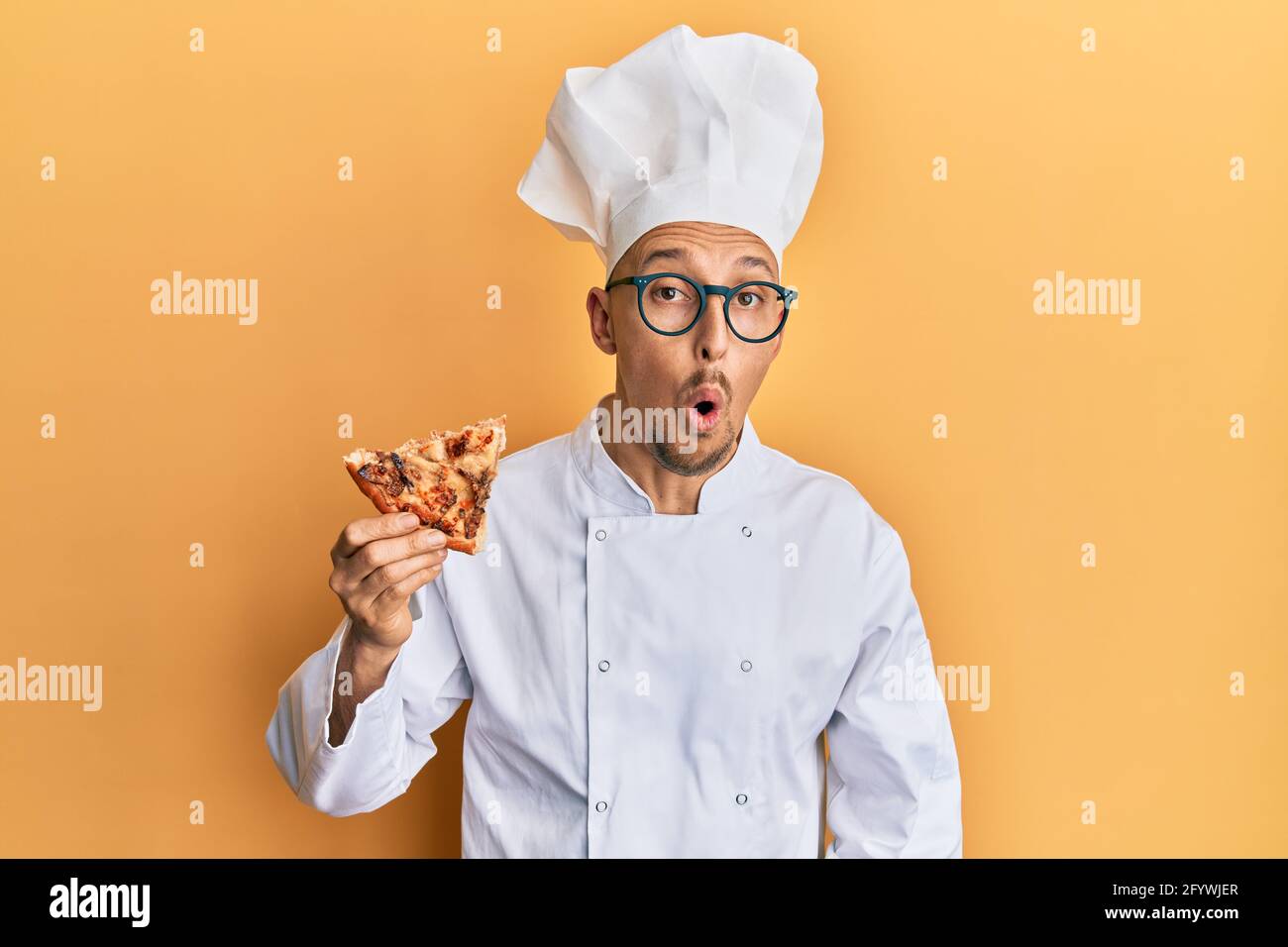 Bald man with beard wearing professional cook apron holding italian ...